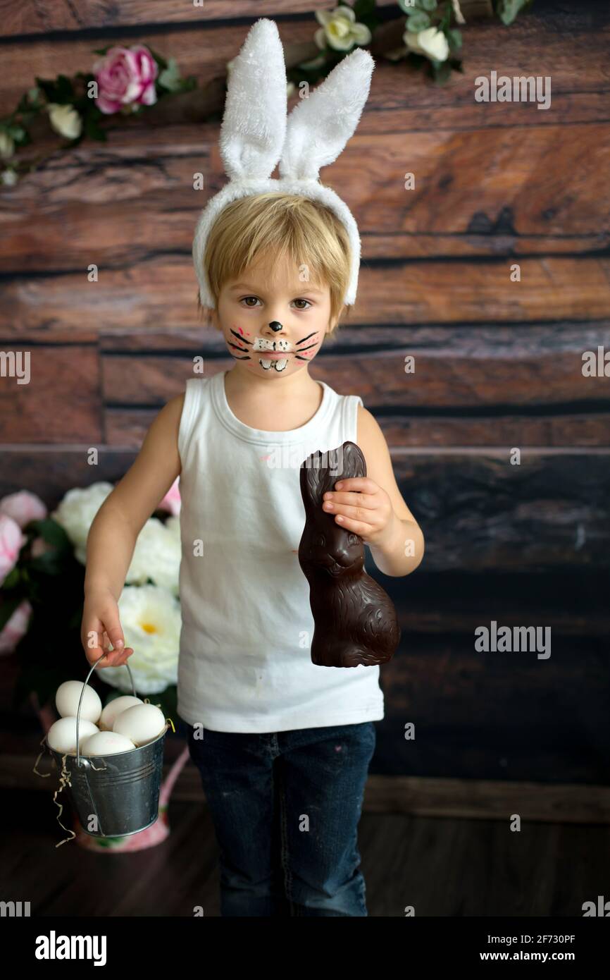 Little toddler boy, child with rabbit painted on the face, eating ...