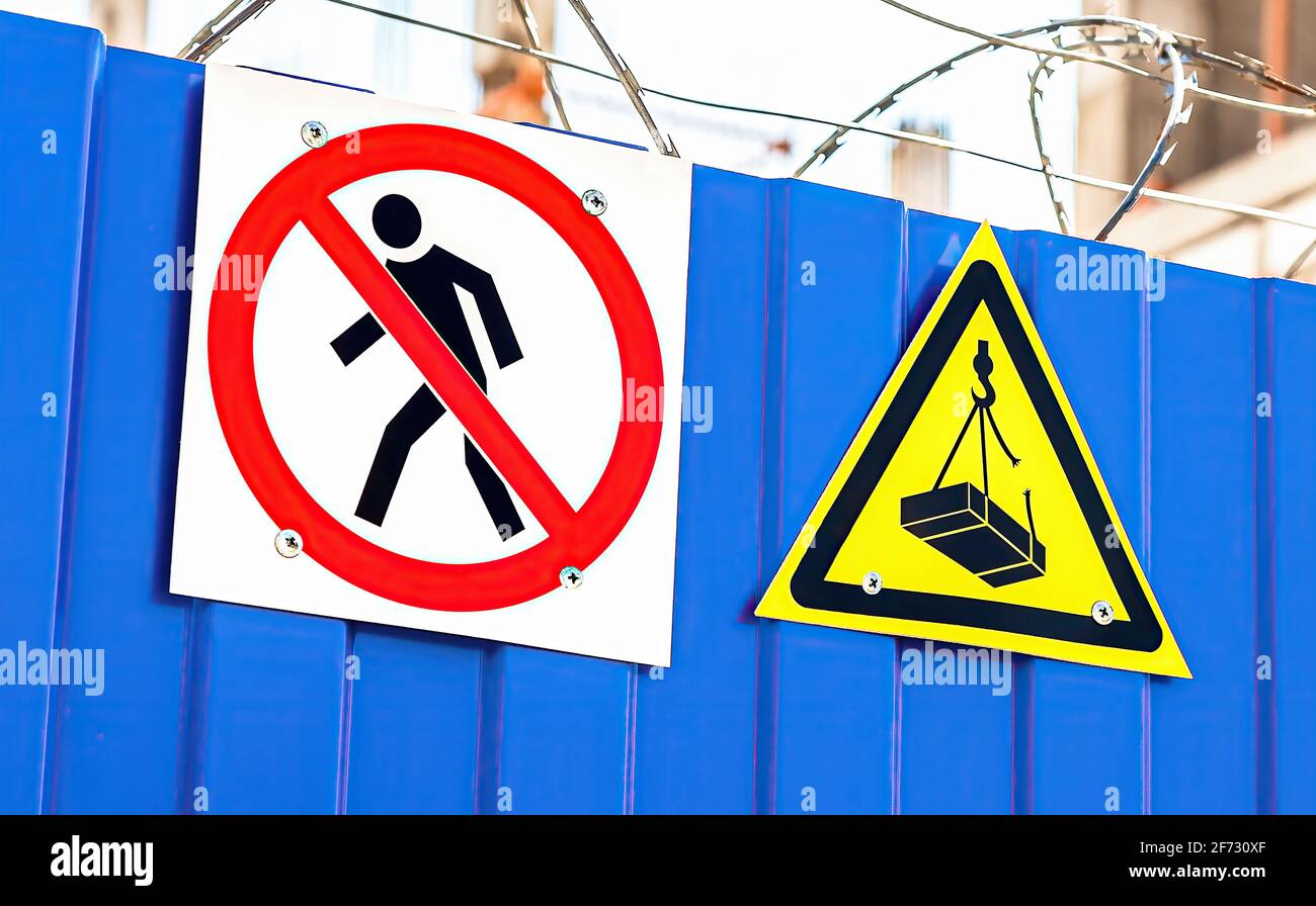 Warning signs and barbed wire on the fence at the construction site ...