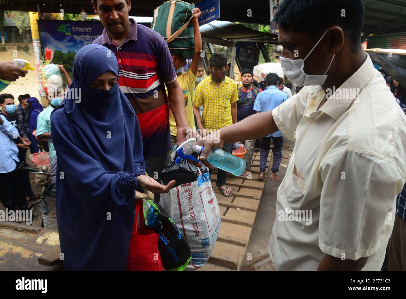 A ferry staff sprays hand sanitizers on passengers hand during onto a ...