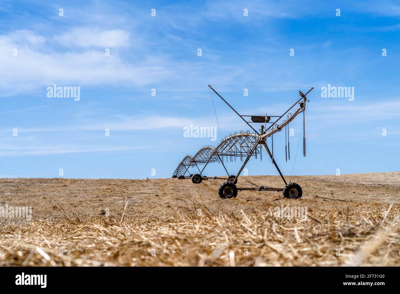 Moving irrigation system standing on a dry stubble field in Alentejo ...