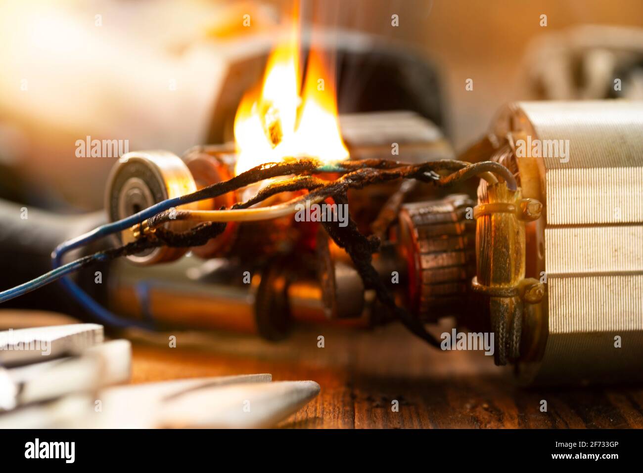 Burning wires on the details of an electrical appliance on a wooden ...