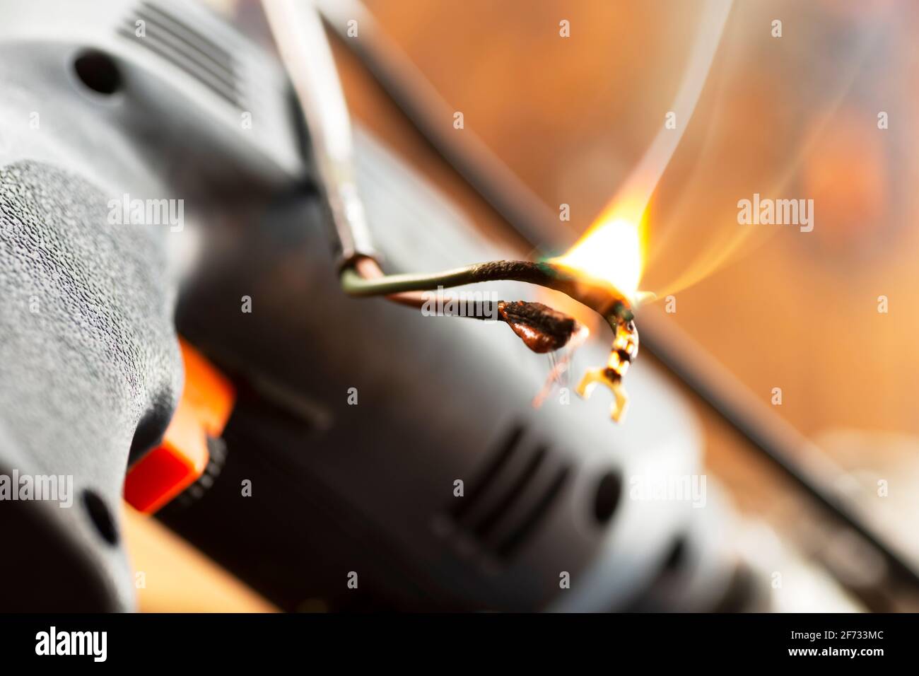 Burning wires on the details of an electrical appliance on a wooden ...