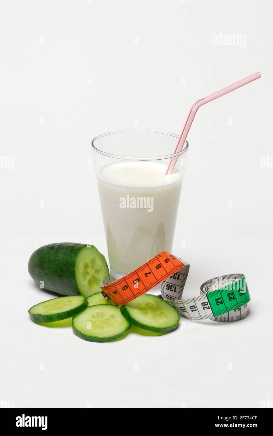 Glass of buttermilk, cucumber, milk, straw, cucumber, measuring tape ...