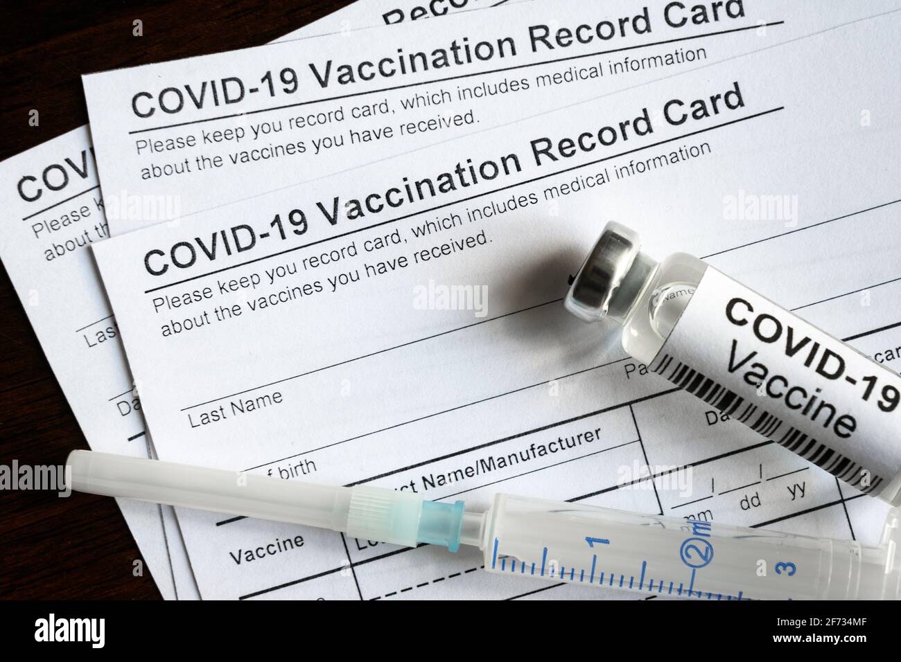 COVID-19 Vaccination Record Card on desk, top view of coronavirus ...