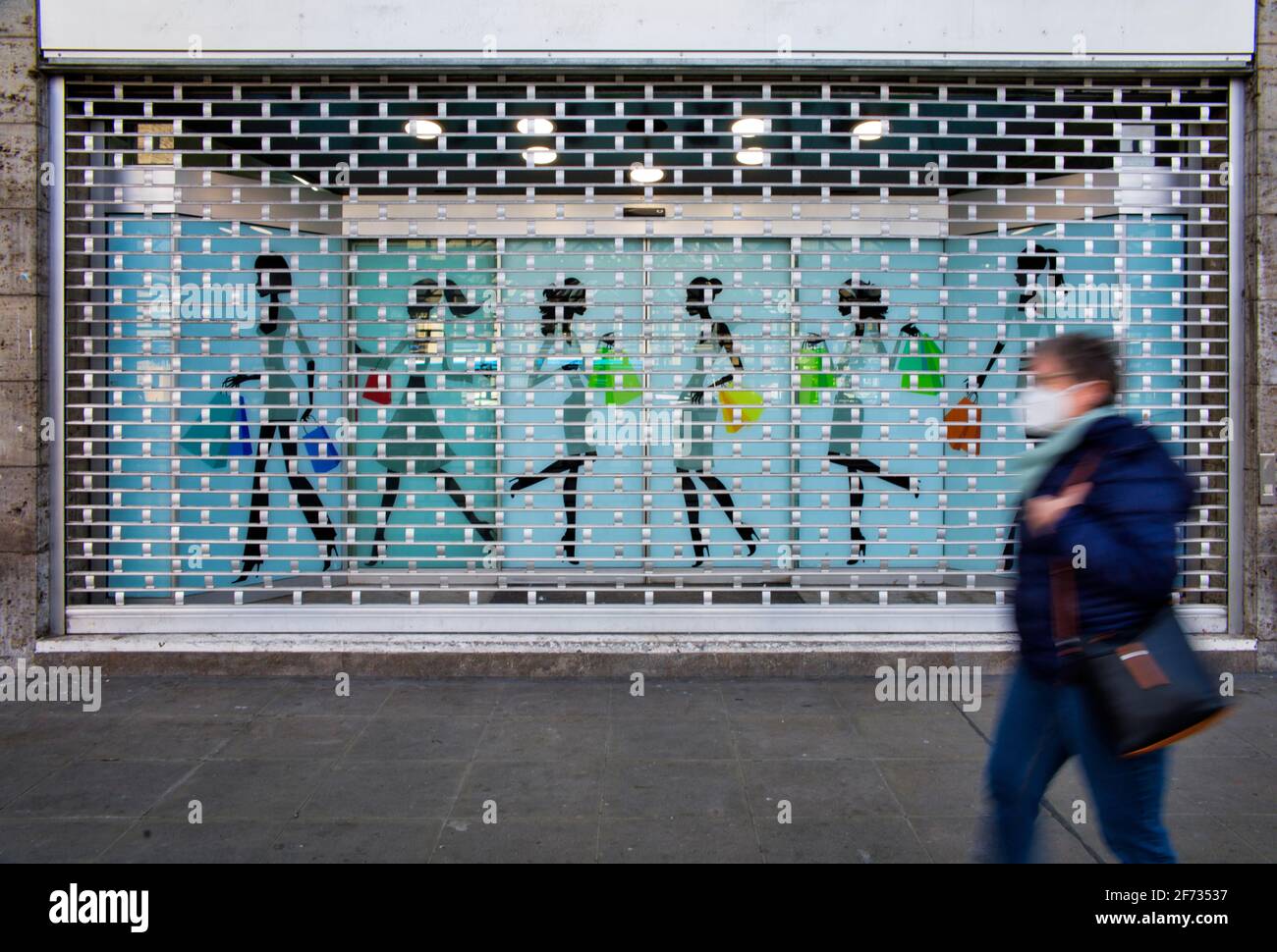 Closed fashion store, bars in front of shop window, customer with mouth ...