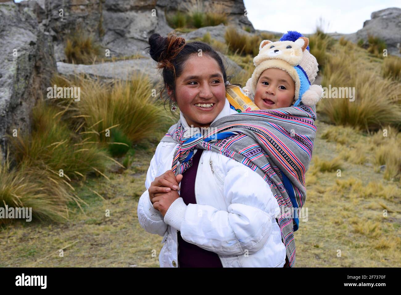 Smiling indigenous woman with infant on her back, Junin province, Peru ...