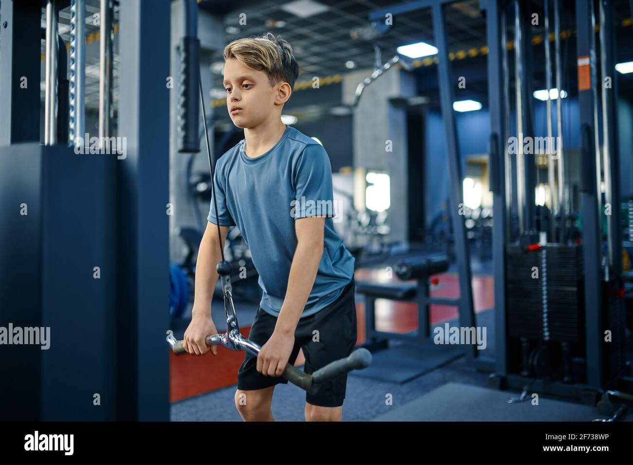 Boy on exercise machine, active training in gym Stock Photo - Alamy