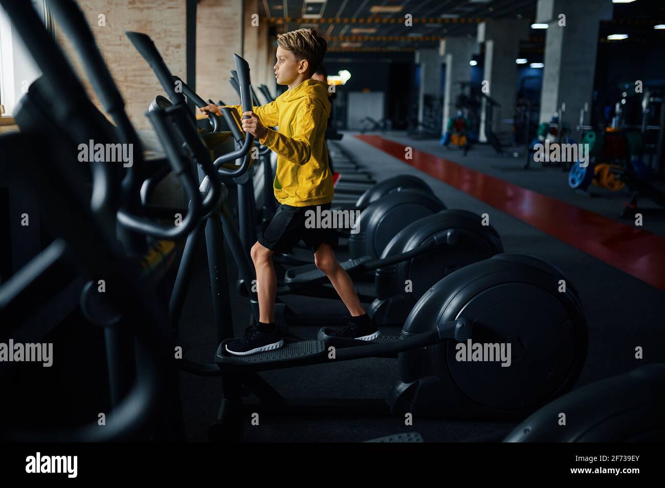 Child on exercise machine, training in gym Stock Photo - Alamy