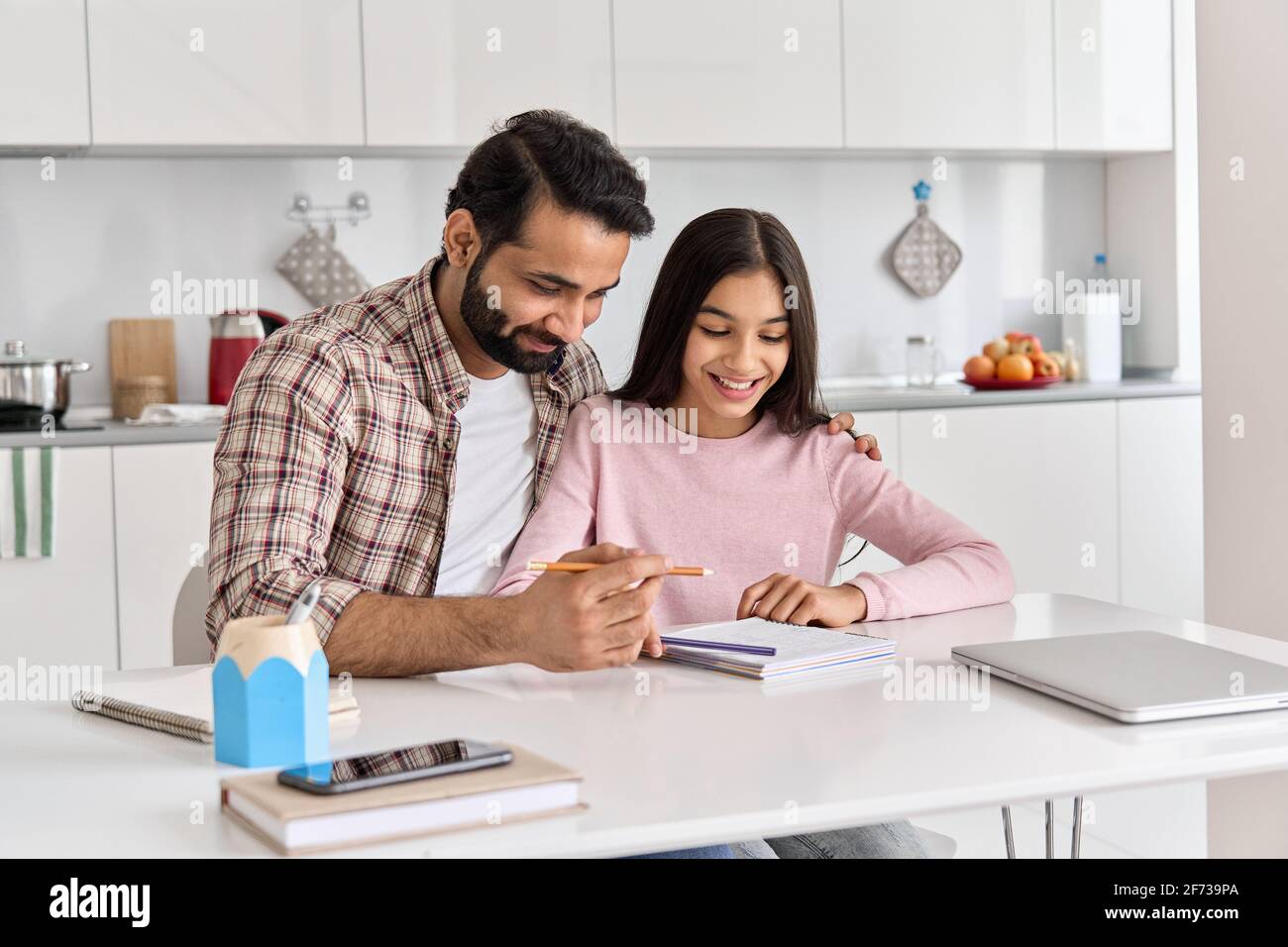Happy indian dad helping school child teen daughter learning at home ...