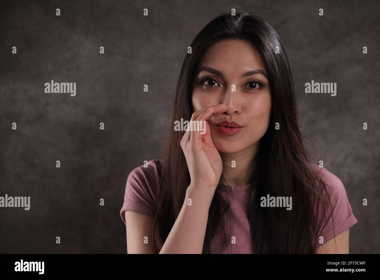 Young woman whispers something to the camera Stock Photo - Alamy