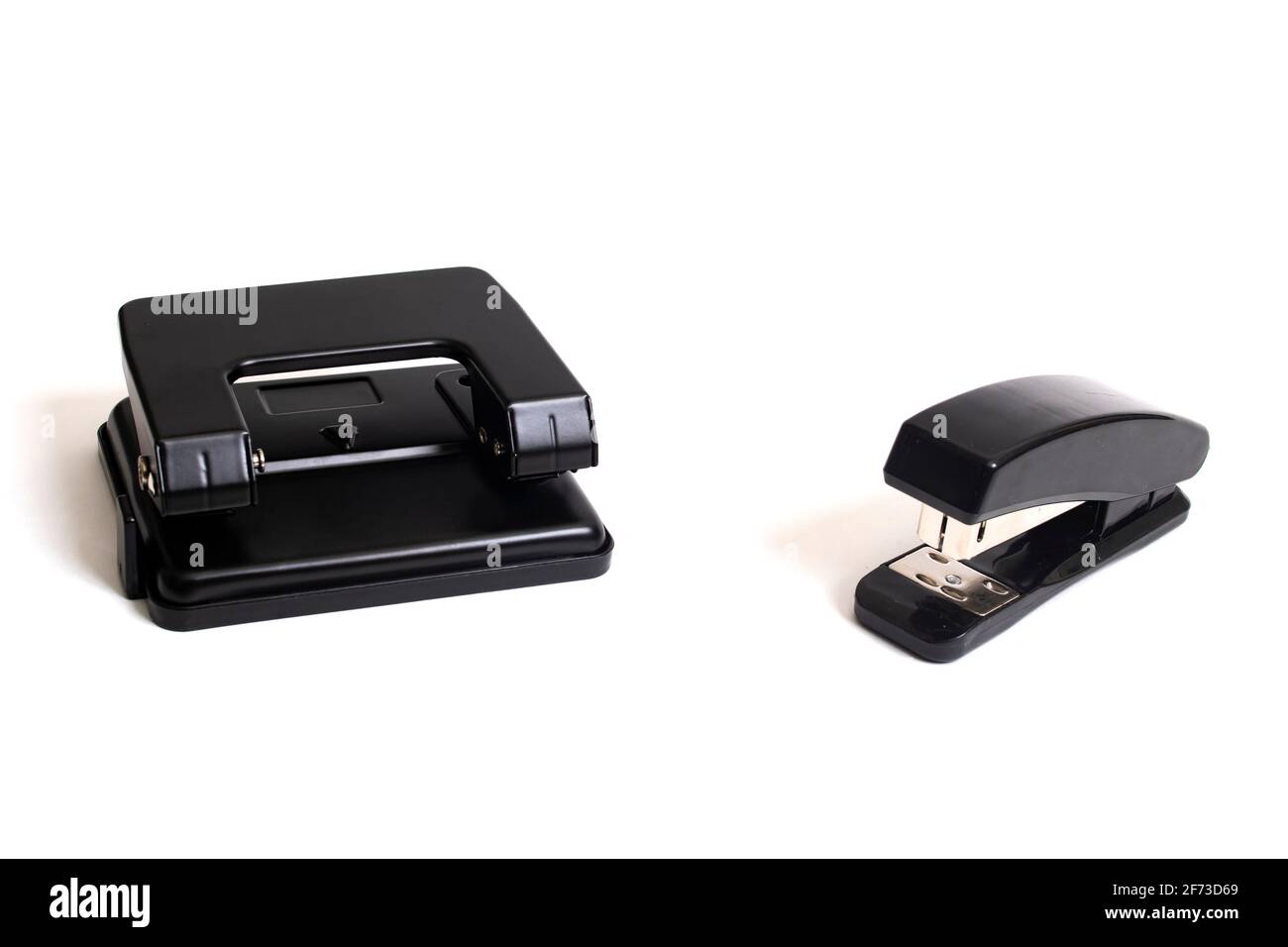 Black hole punch and stapler isolated on white background close up ...