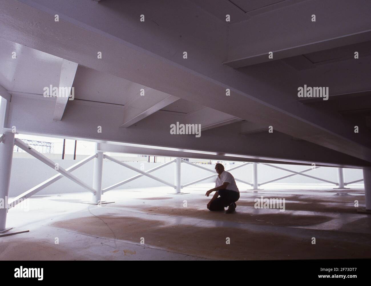 Inspector checks underneath an industrial water treatment tank at an ...