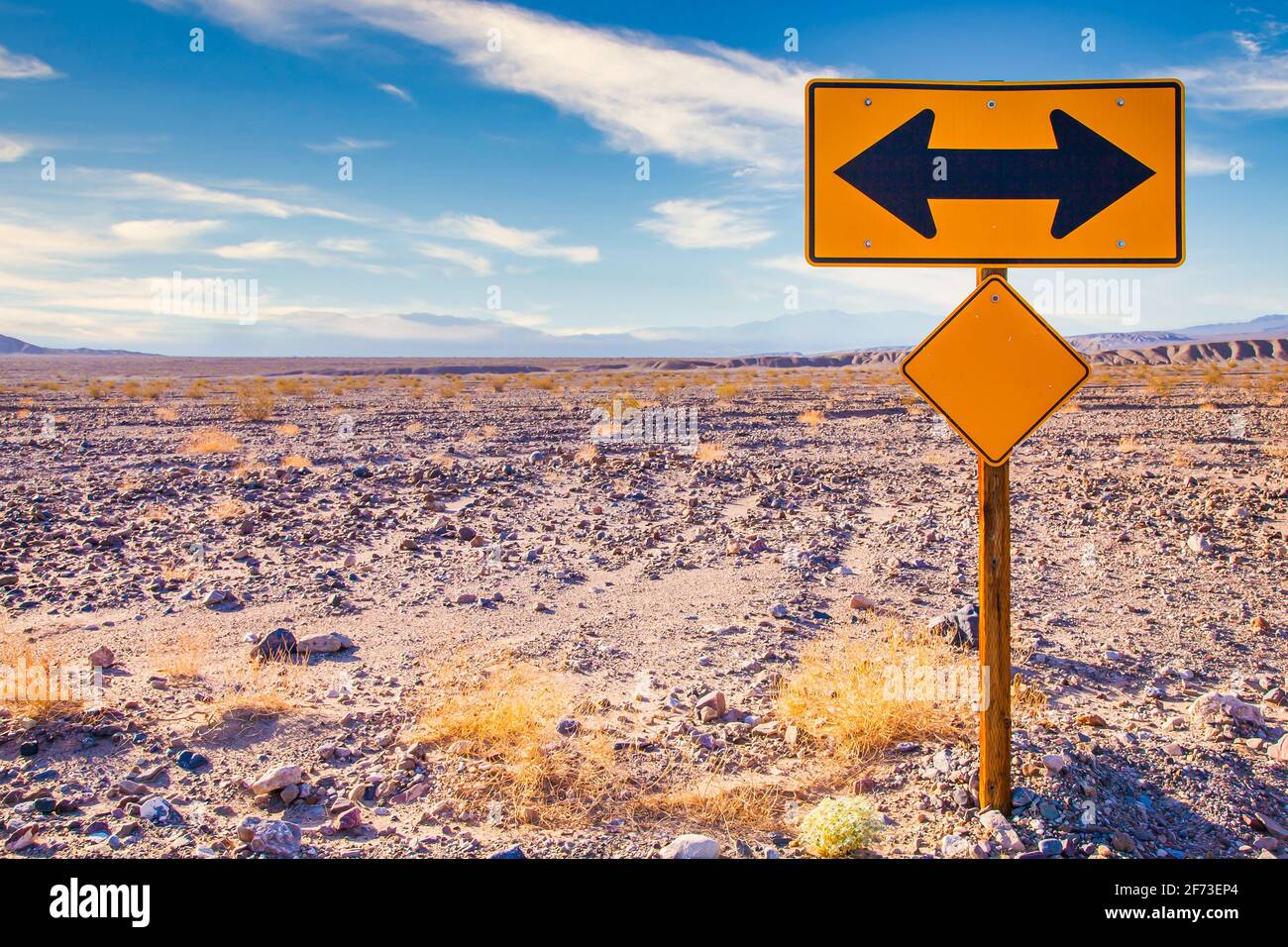 Directional sign in the desert with scenic blue sky and wide horizon ...