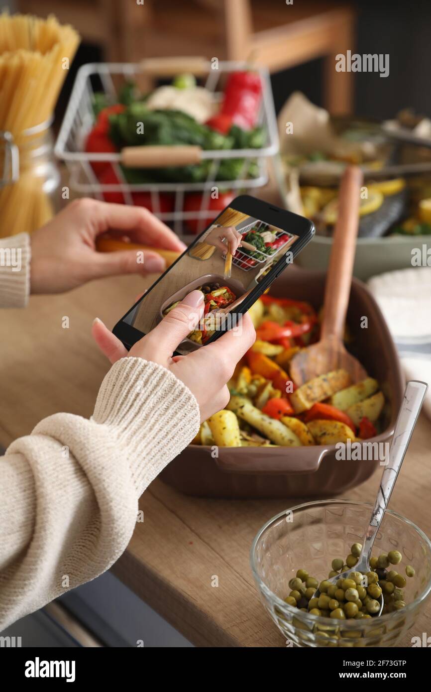 Female food photographer with mobile phone taking picture of tasty ...