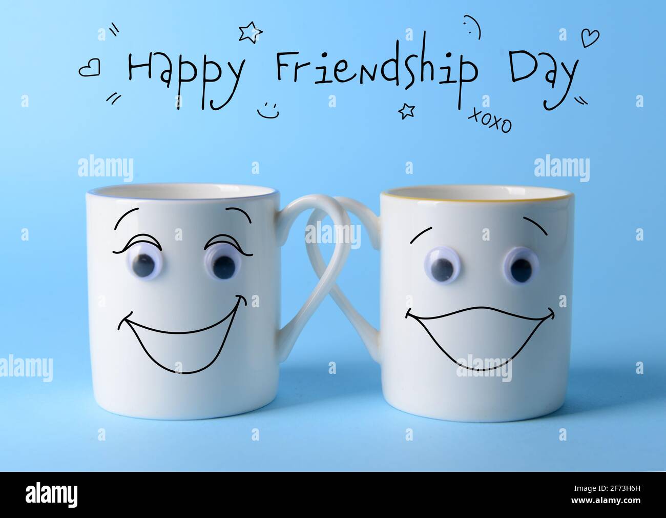 Funny cups on color background. Friendship Day celebration Stock Photo ...