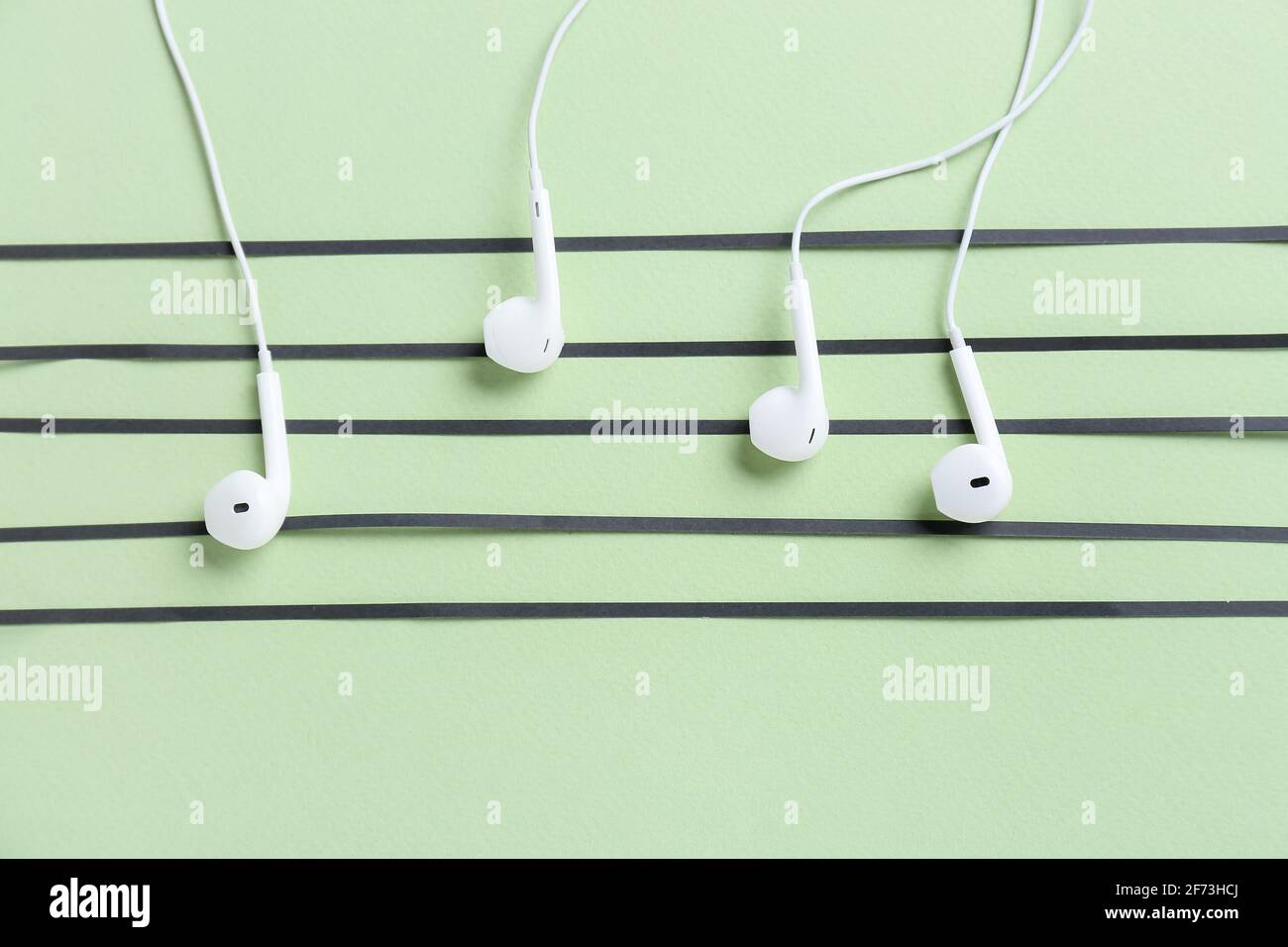Music notes made of modern earphones on color background Stock Photo ...