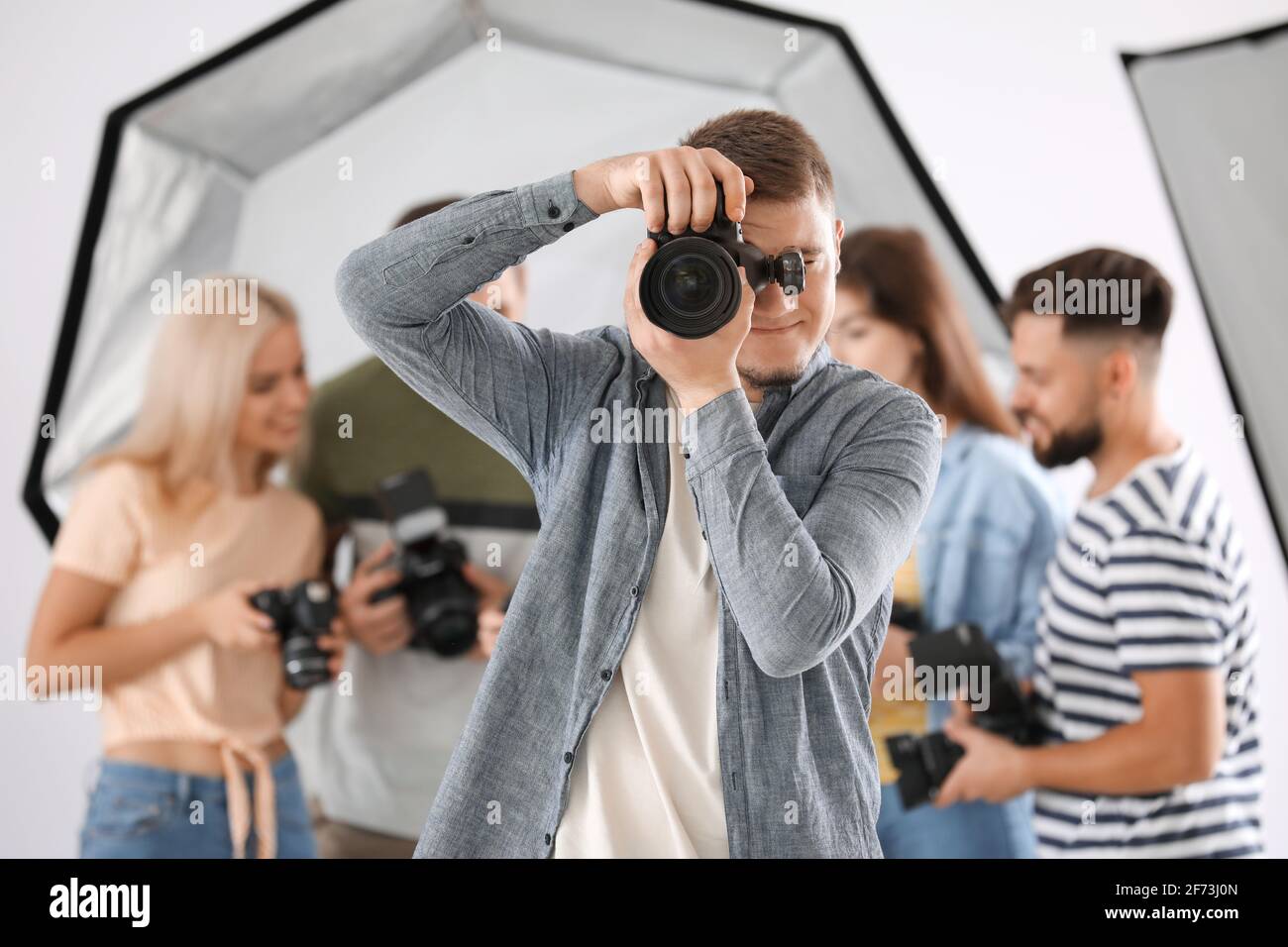 Male photographer taking picture in studio Stock Photo - Alamy