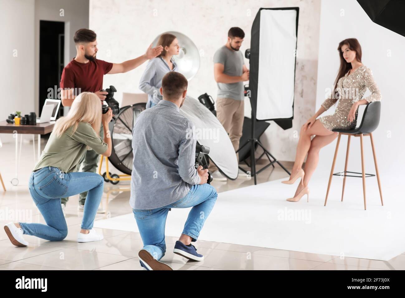 Young photographers taking picture of woman in studio Stock Photo - Alamy