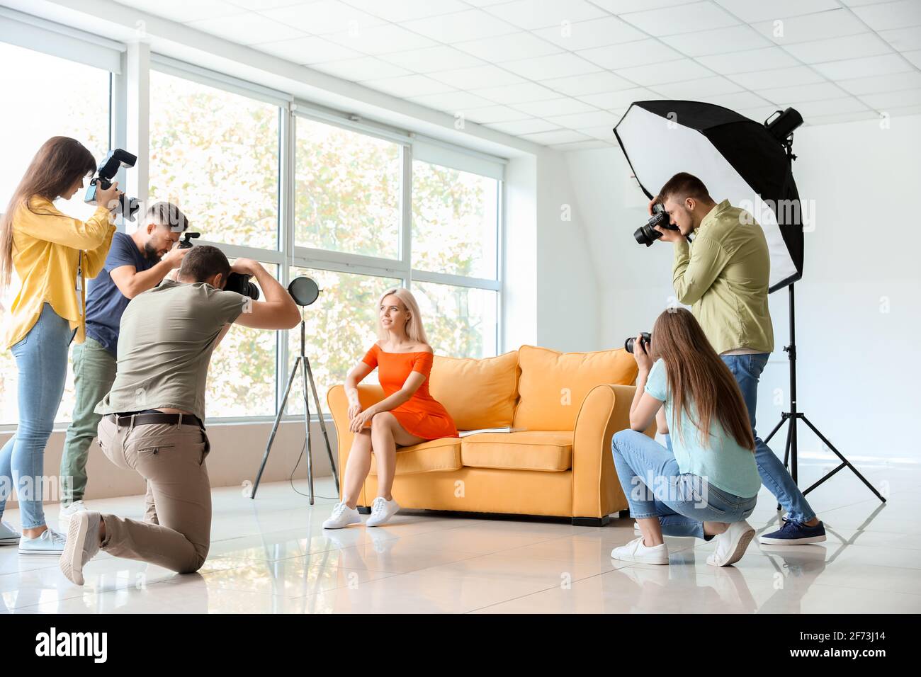 Young photographers taking picture of woman in studio Stock Photo - Alamy