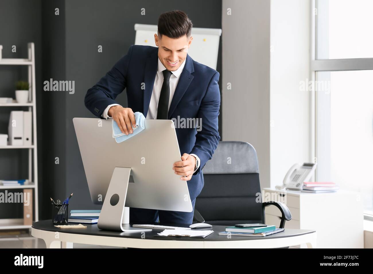Young businessman cleaning computer in office Stock Photo - Alamy
