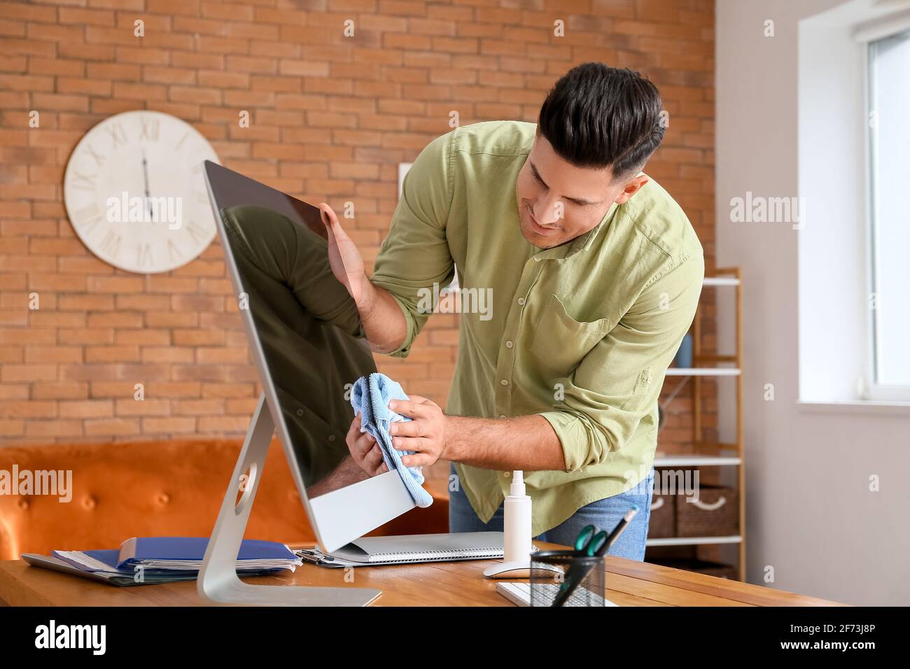 Young man cleaning computer at home Stock Photo - Alamy