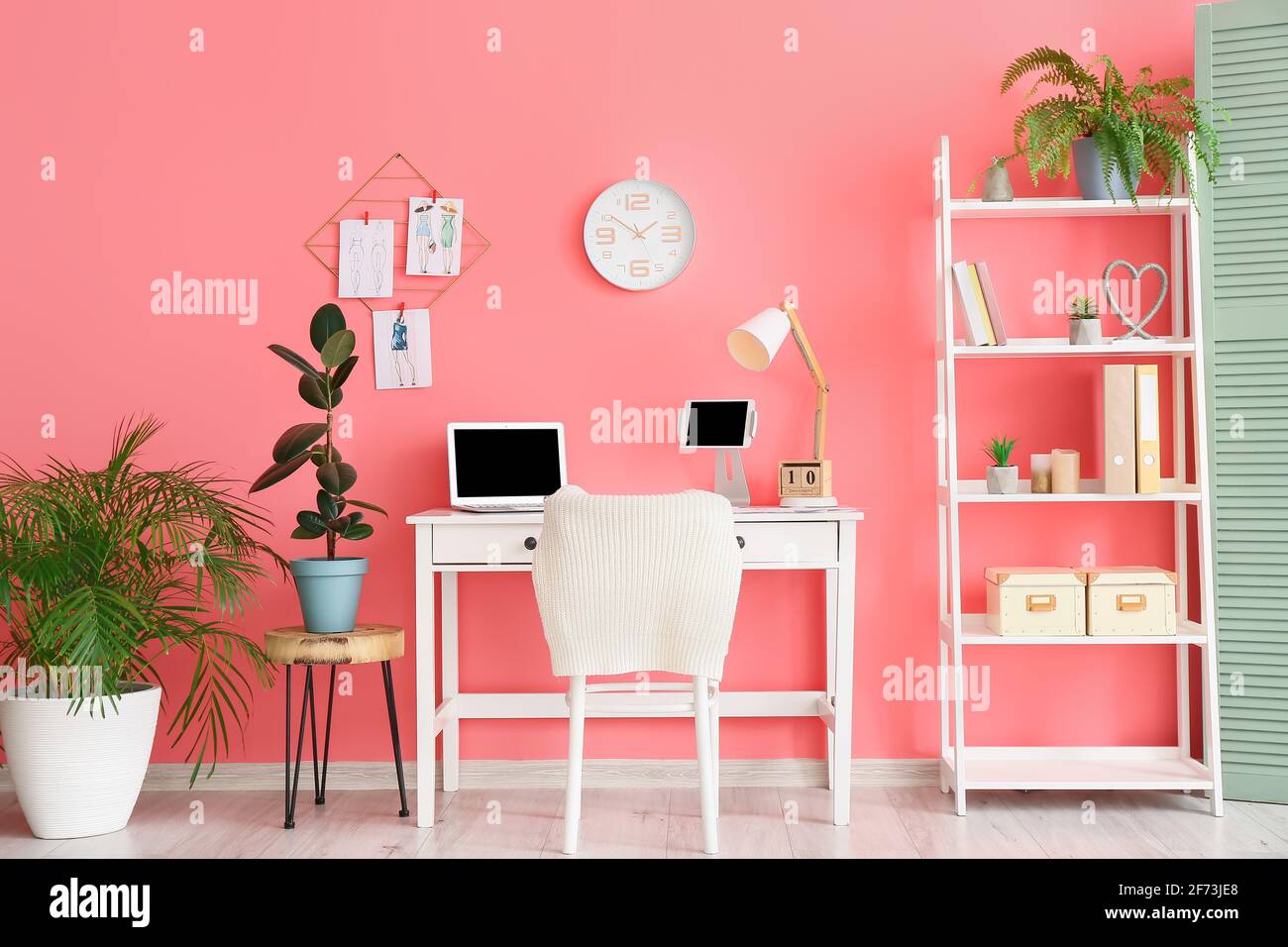 Stylish workplace with laptop near color wall in office Stock Photo - Alamy