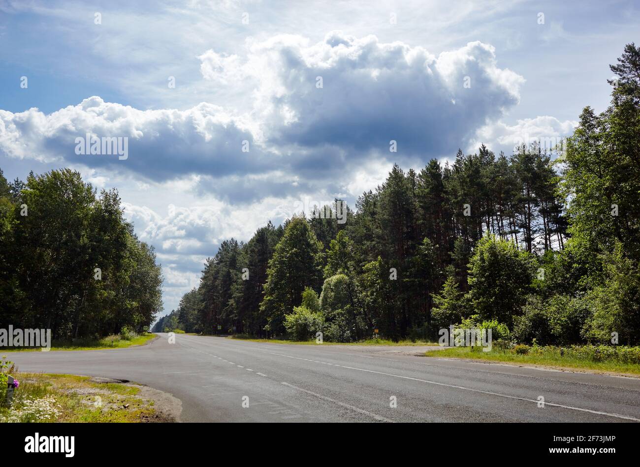 Asphalt crossroad suburban road. Road with green trees against cloudy ...