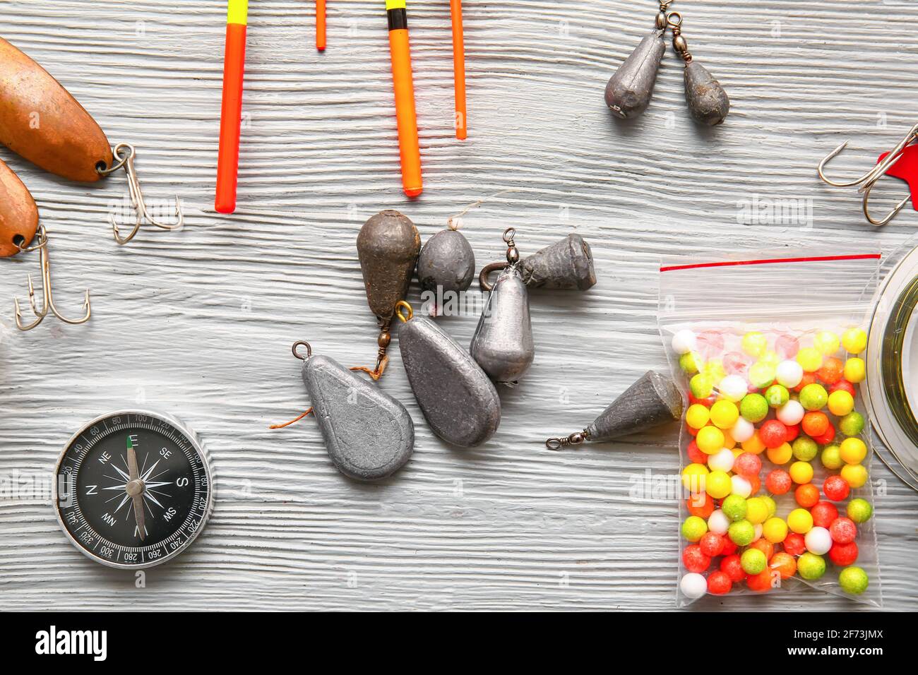 Different fishing equipment on light wooden background Stock Photo - Alamy