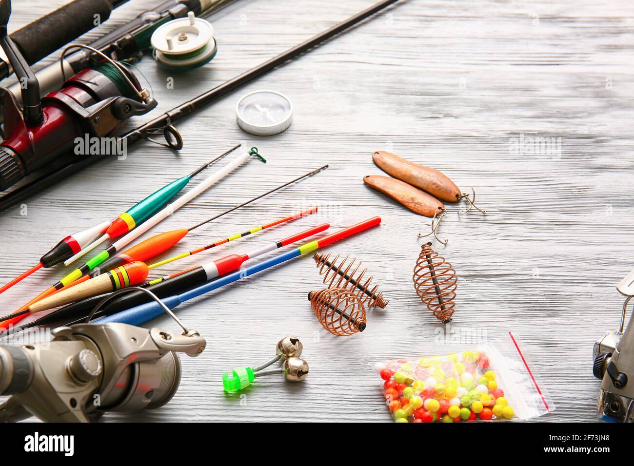 Different fishing equipment on light wooden background Stock Photo - Alamy