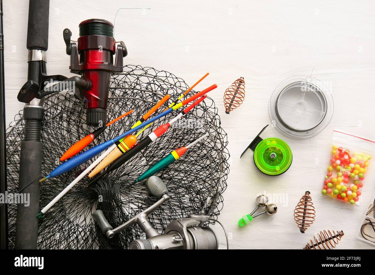 Different fishing equipment on light wooden background Stock Photo - Alamy