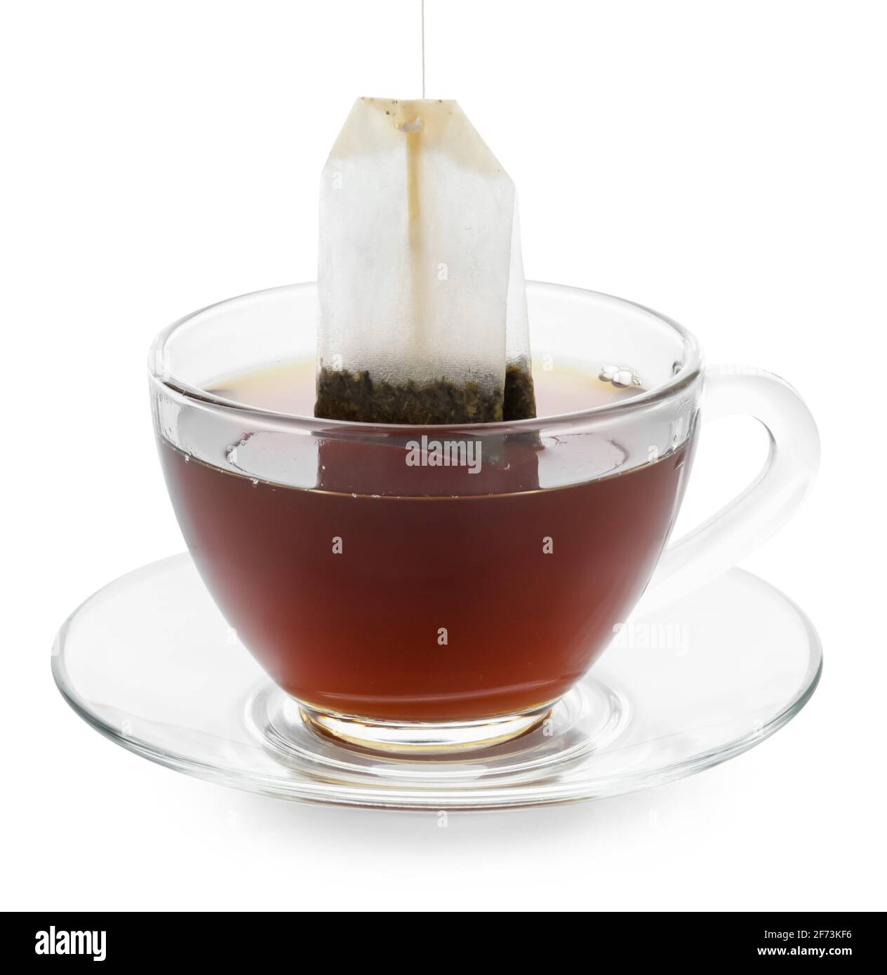 Taking tea bag out of glass cup with hot beverage on white background ...