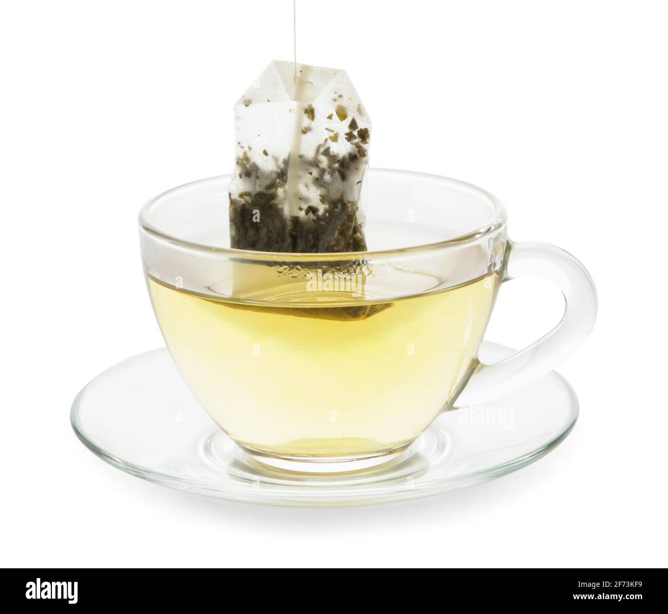 Taking tea bag out of glass cup with hot beverage on white background ...