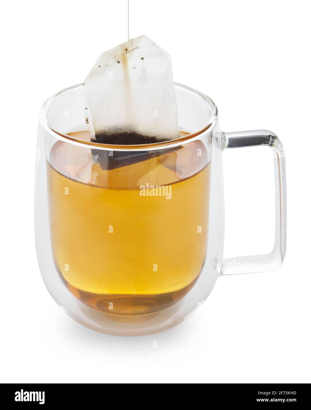 Taking tea bag out of glass cup with hot beverage on white background ...