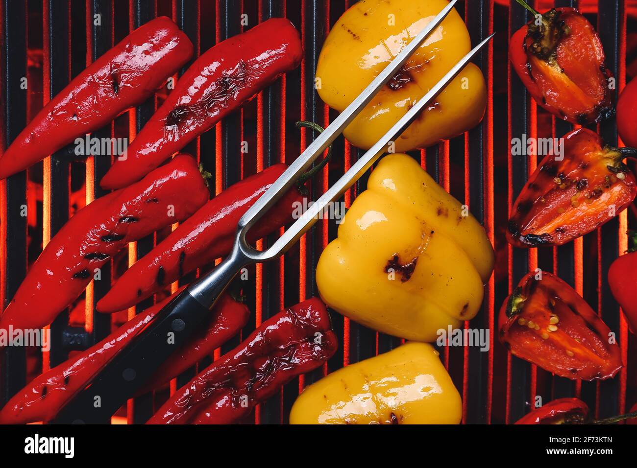 Different tasty peppers cooking on grill Stock Photo - Alamy