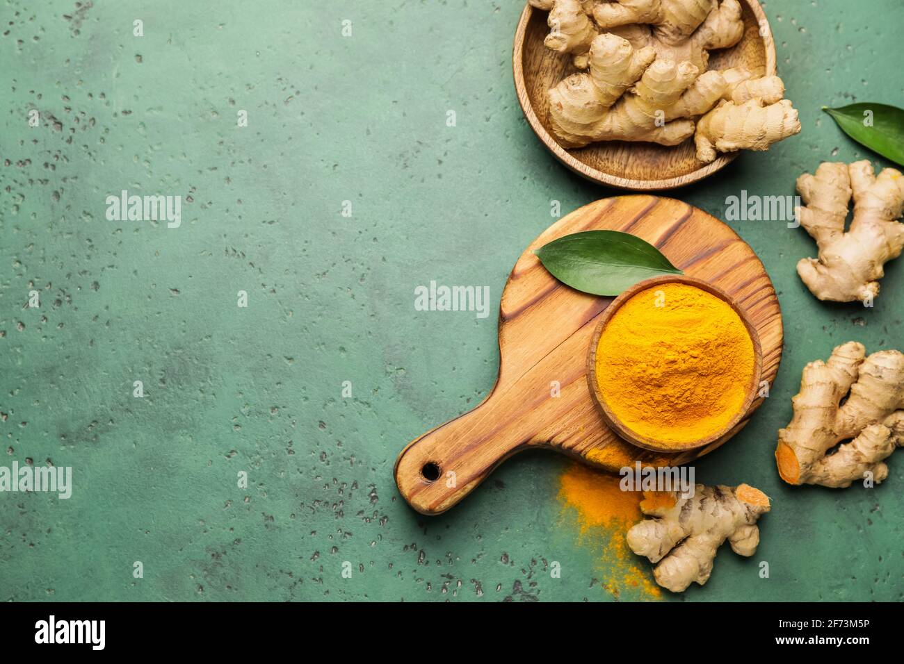 Composition with turmeric powder and roots on color background Stock ...