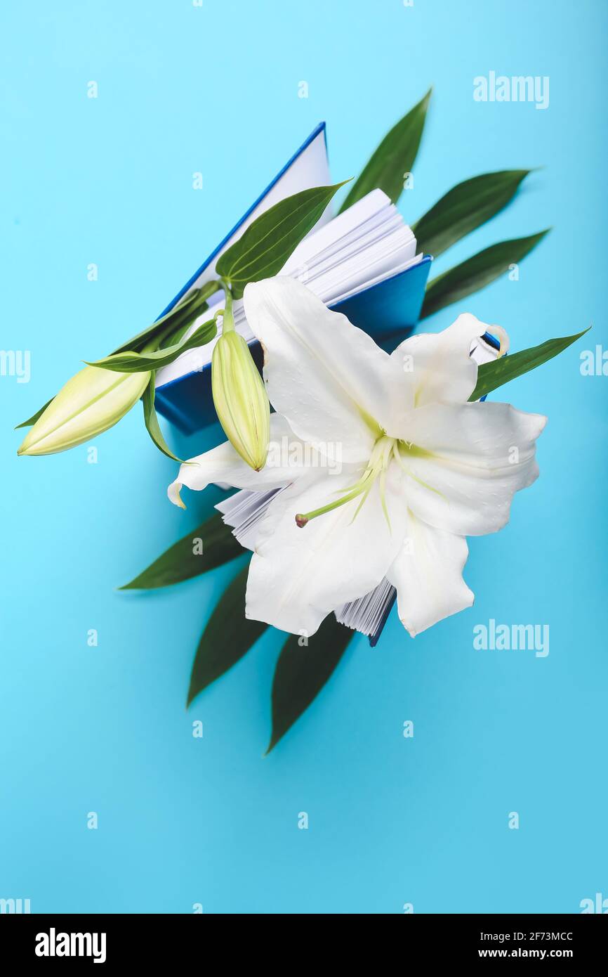 Books with beautiful lily flowers on color background Stock Photo - Alamy