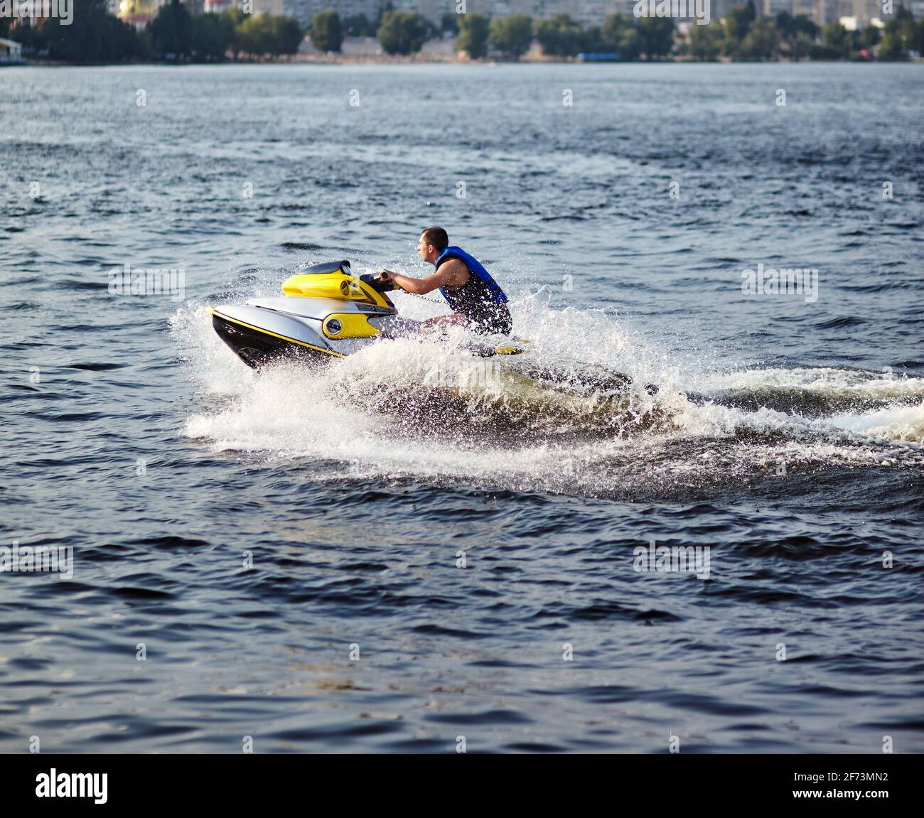 Strong man jumps on the jetski above the water. Man speeding on jet ski ...