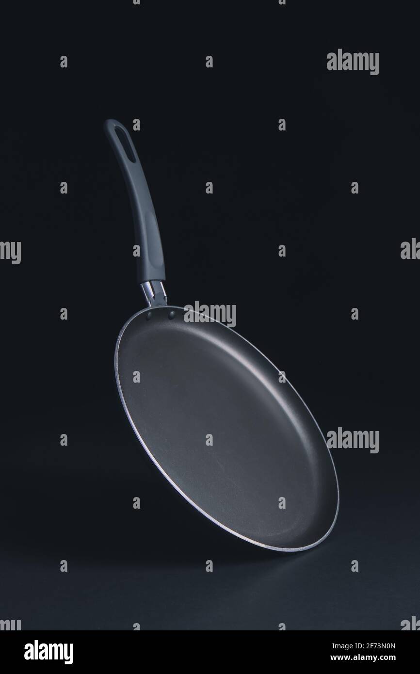 Frying pan on dark background Stock Photo - Alamy