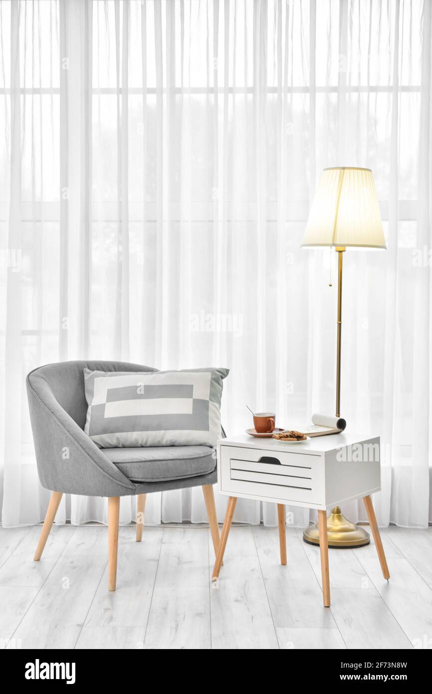 Interior of modern room with armchair and table Stock Photo - Alamy
