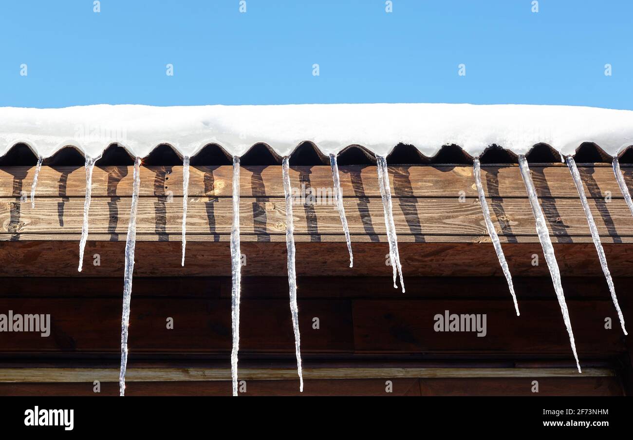 Icicles in winter. Ice stalactite hanging from the roof of building ...