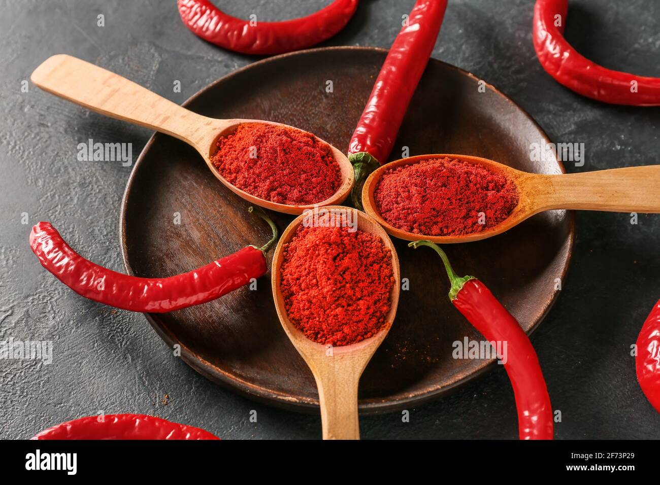 Spoons with red chili powder on dark background Stock Photo - Alamy