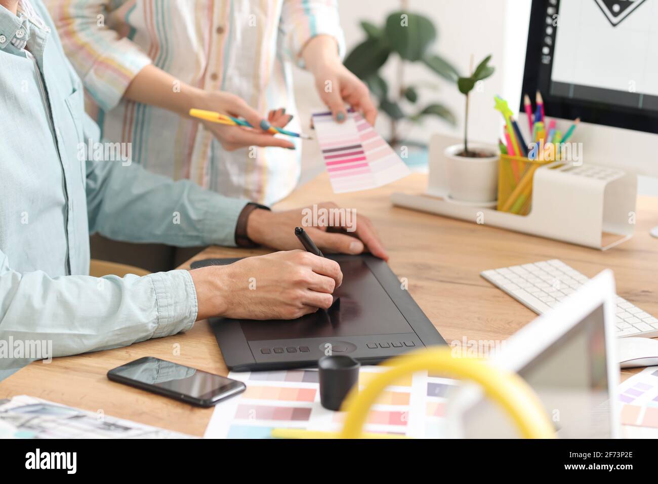 Graphic designer with colleague working in office Stock Photo - Alamy