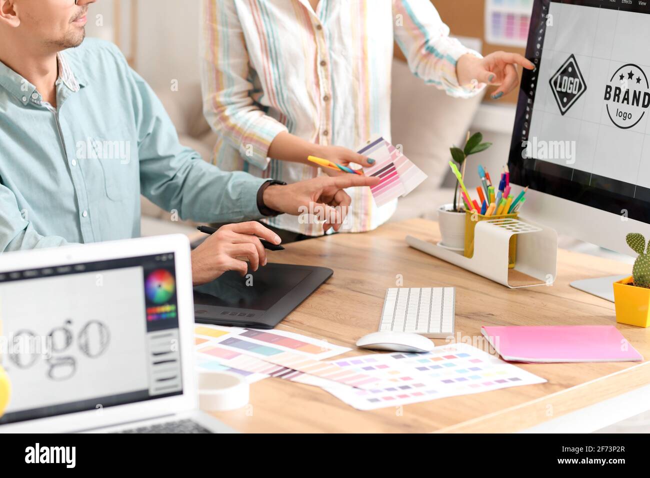 Graphic designer with colleague working in office Stock Photo - Alamy