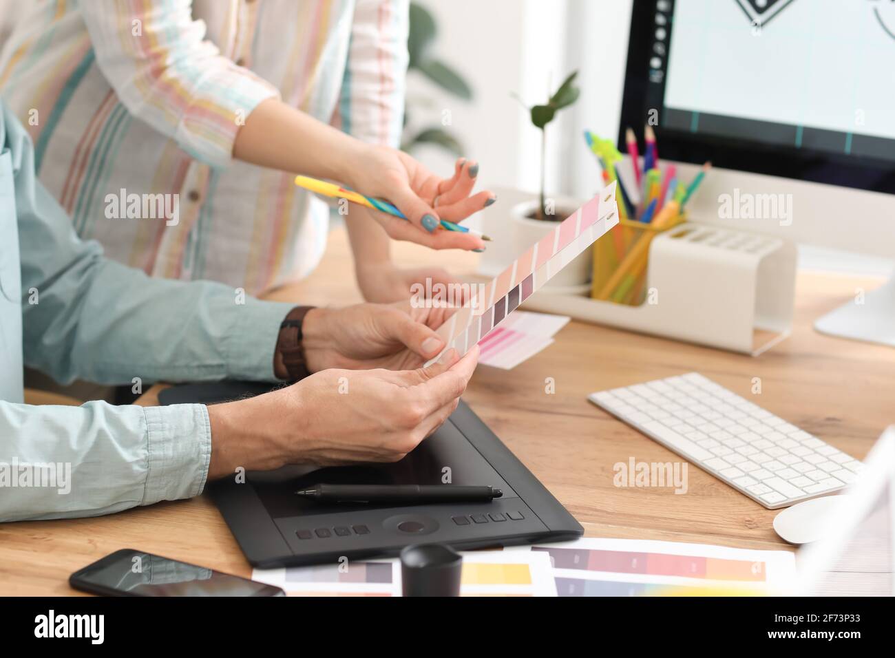 Graphic designer with colleague working in office Stock Photo - Alamy