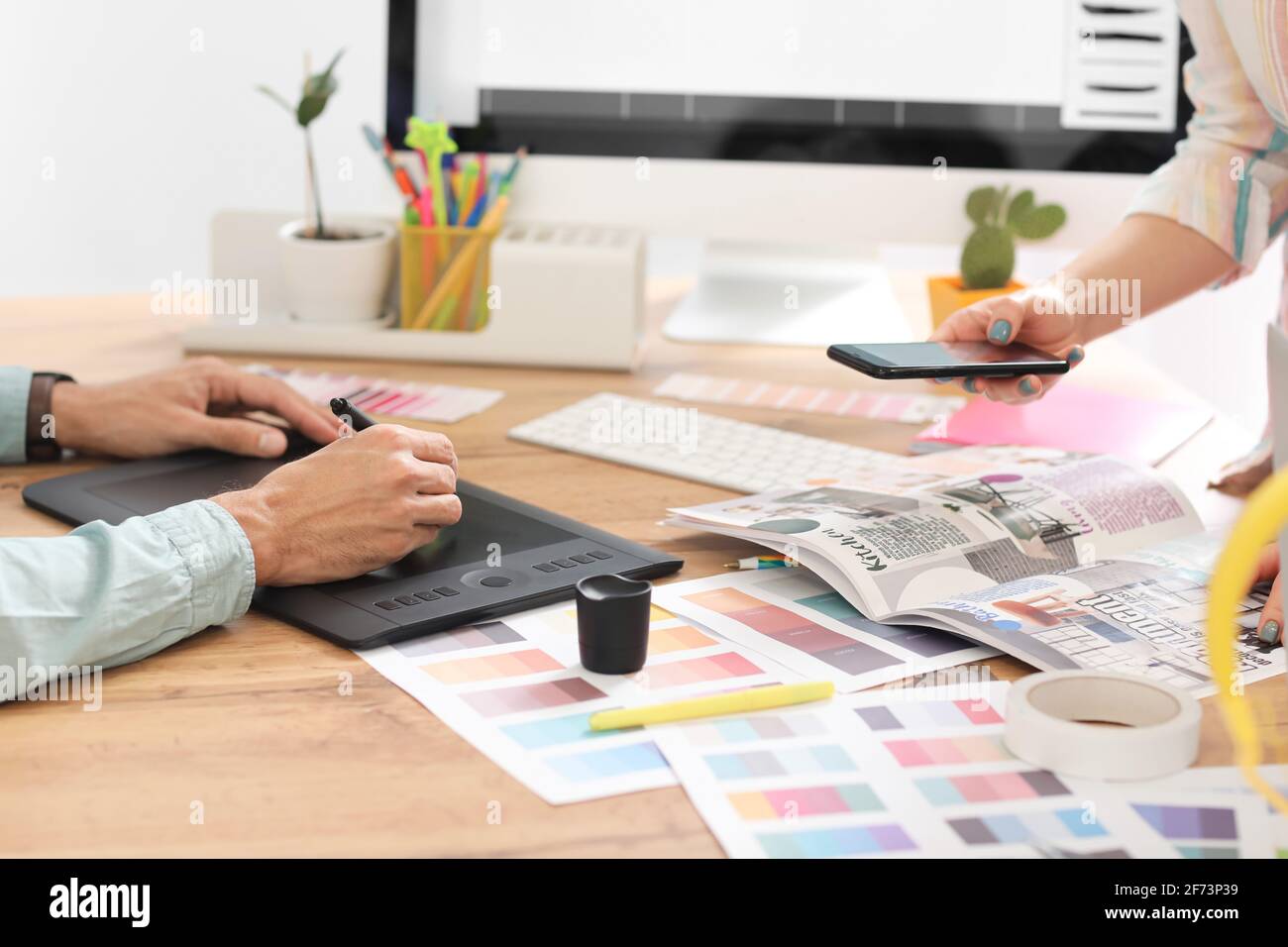 Graphic designer with colleague working in office Stock Photo - Alamy