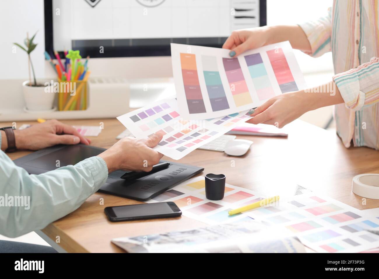 Graphic designer with colleague working in office Stock Photo - Alamy