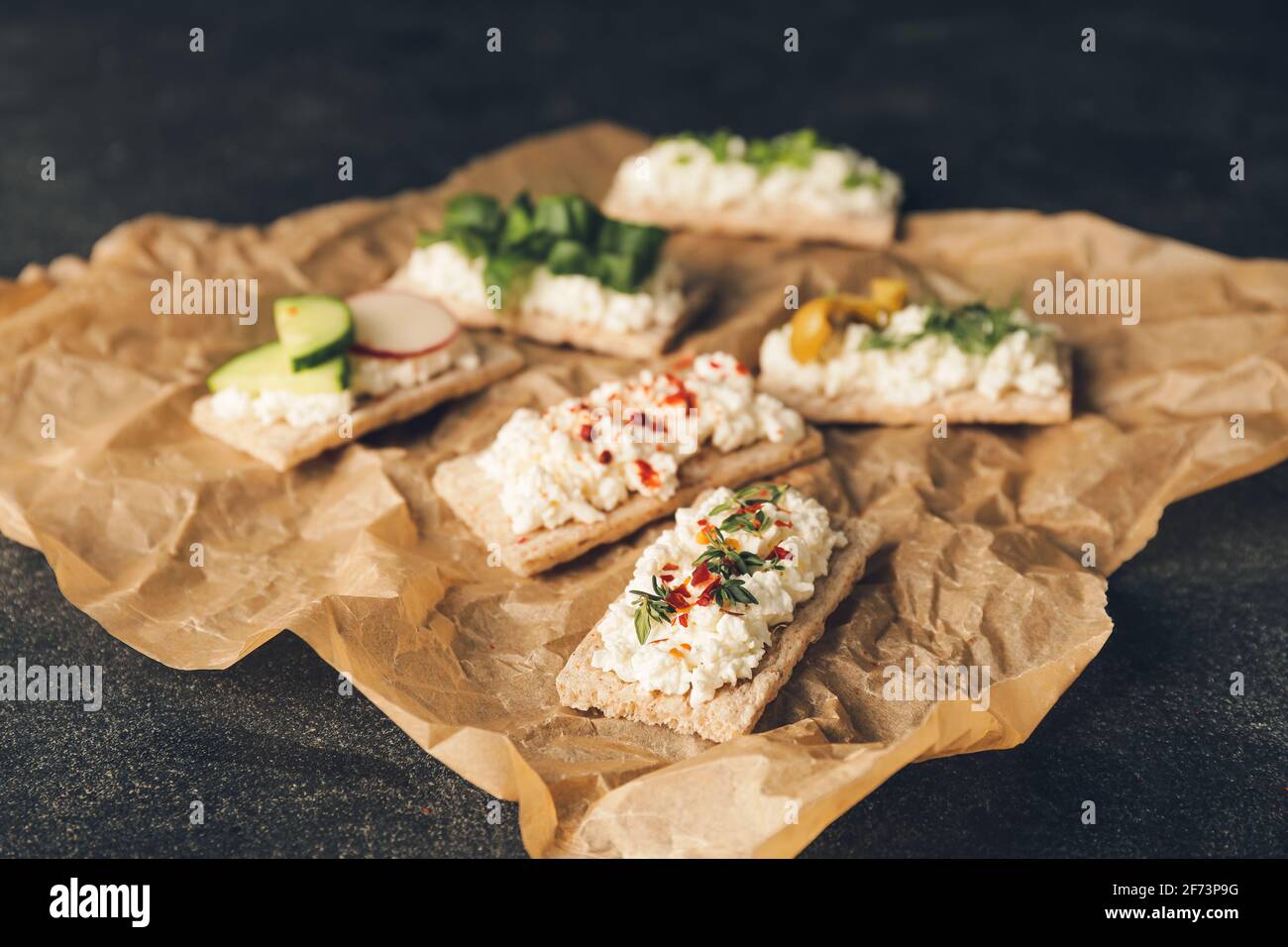 Crispbreads with cottage cheese and vegetables on dark background Stock ...