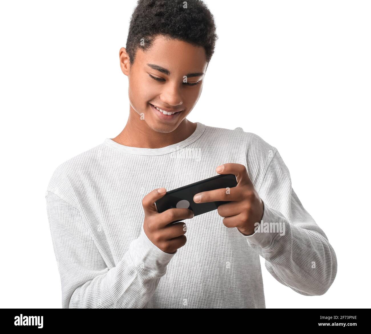 African-American teenage boy with mobile phone on white background ...