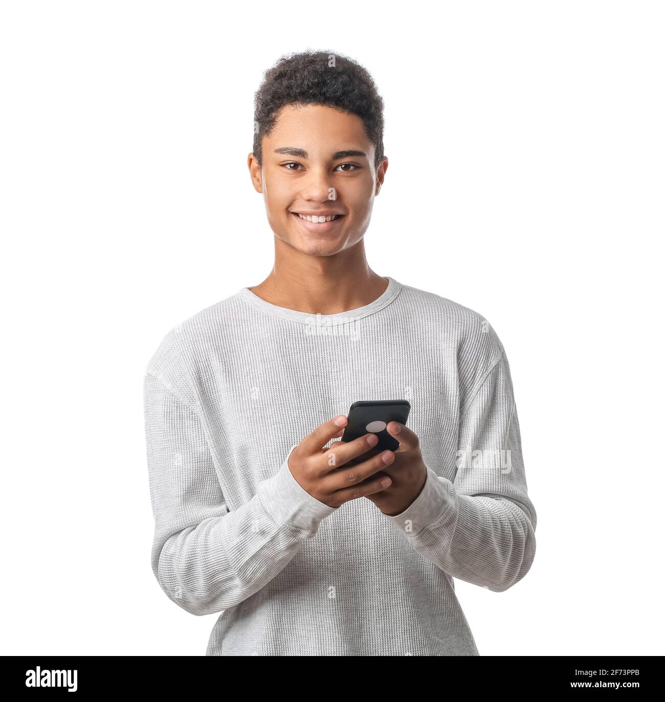 African-American teenage boy with mobile phone on white background ...