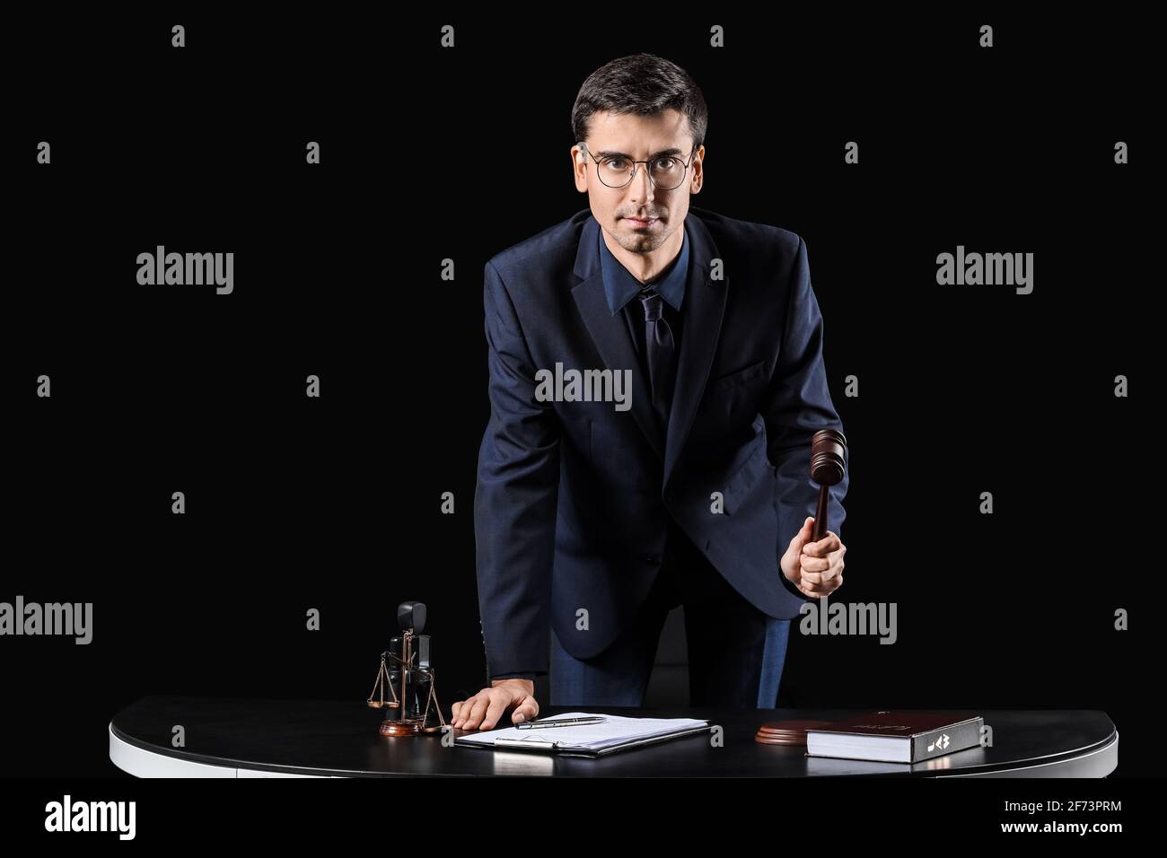 Male judge at table on dark background Stock Photo - Alamy